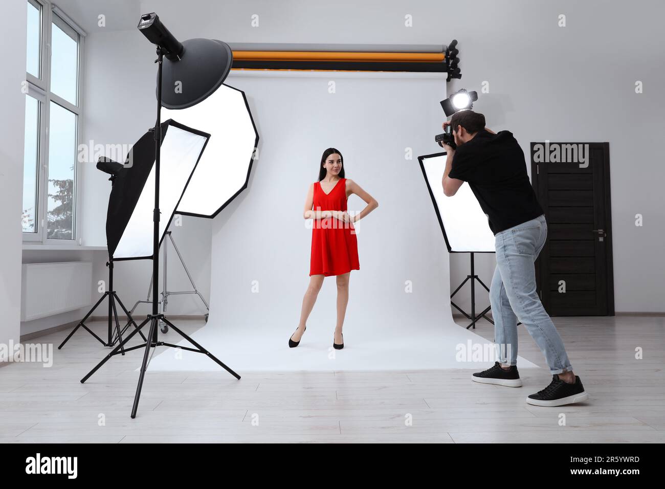 Beautiful young model posing for professional photographer in studio ...