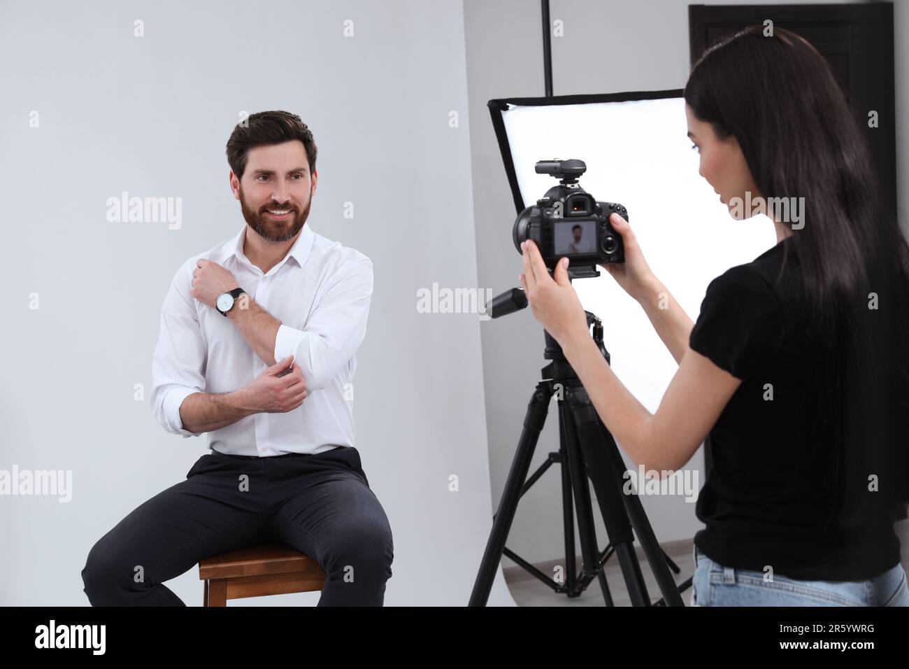Professional photographer working with handsome model in modern photo ...