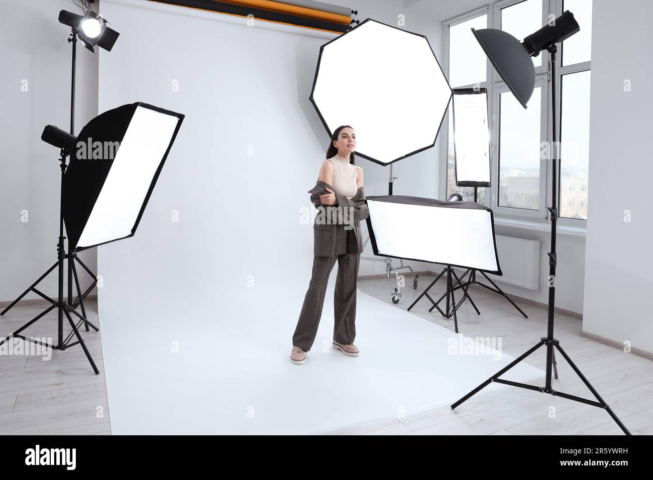 Beautiful young model posing in modern studio. Professional photo ...