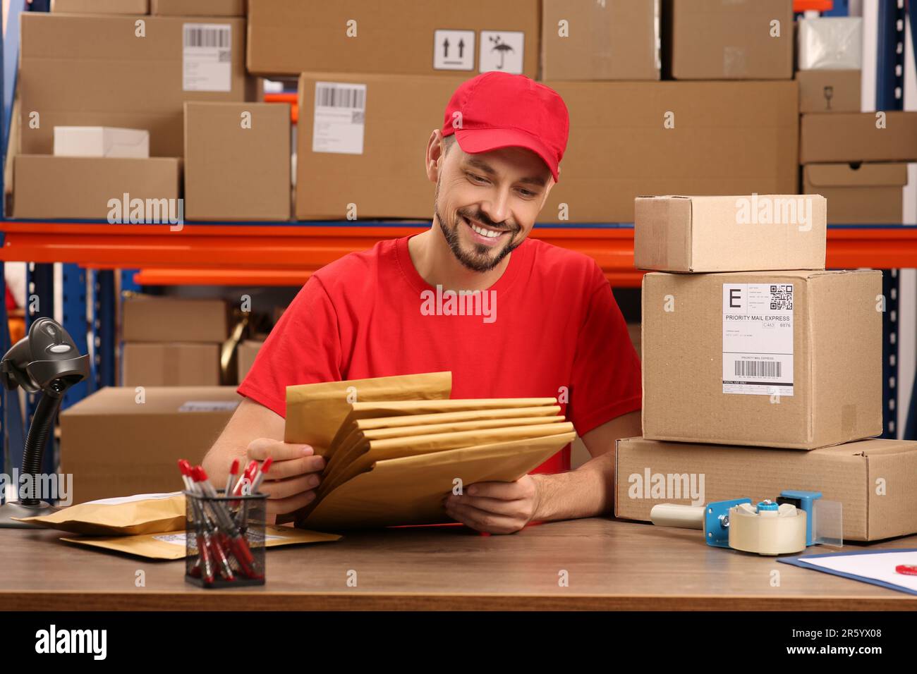 Post office worker with adhesive paper bags at counter indoors Stock ...