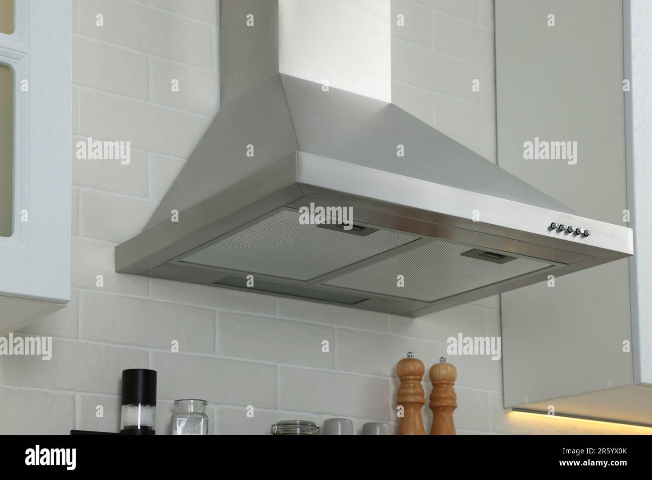 Modern range hood over shelf with spices in kitchen Stock Photo - Alamy