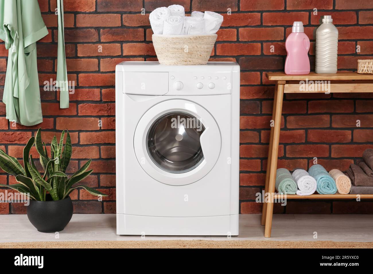 Washing machine and wooden console table with terry towels indoors ...
