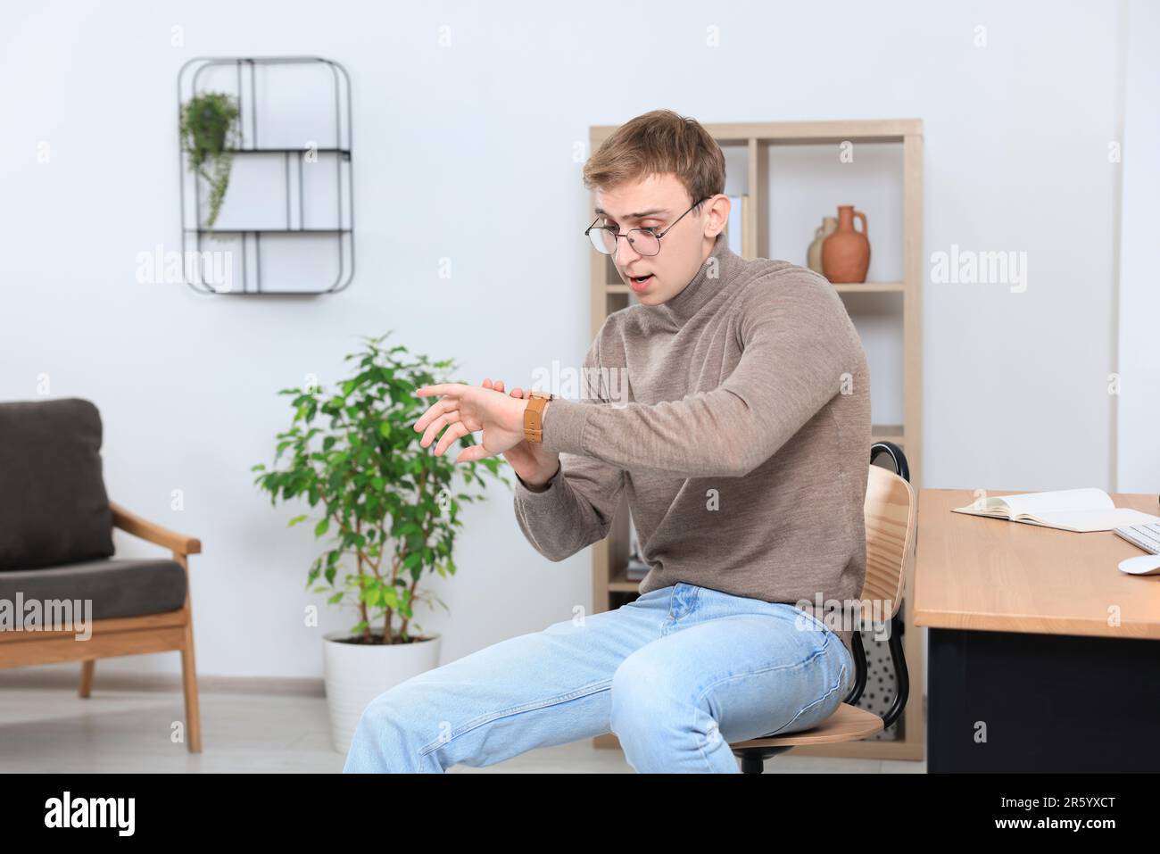 Emotional young man checking time in office. Being late Stock Photo - Alamy