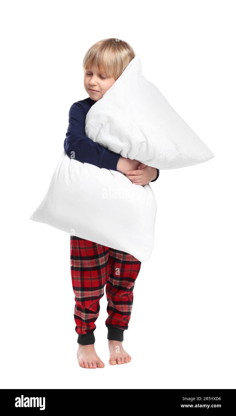 Boy in pajamas hugging pillow on white background Stock Photo - Alamy