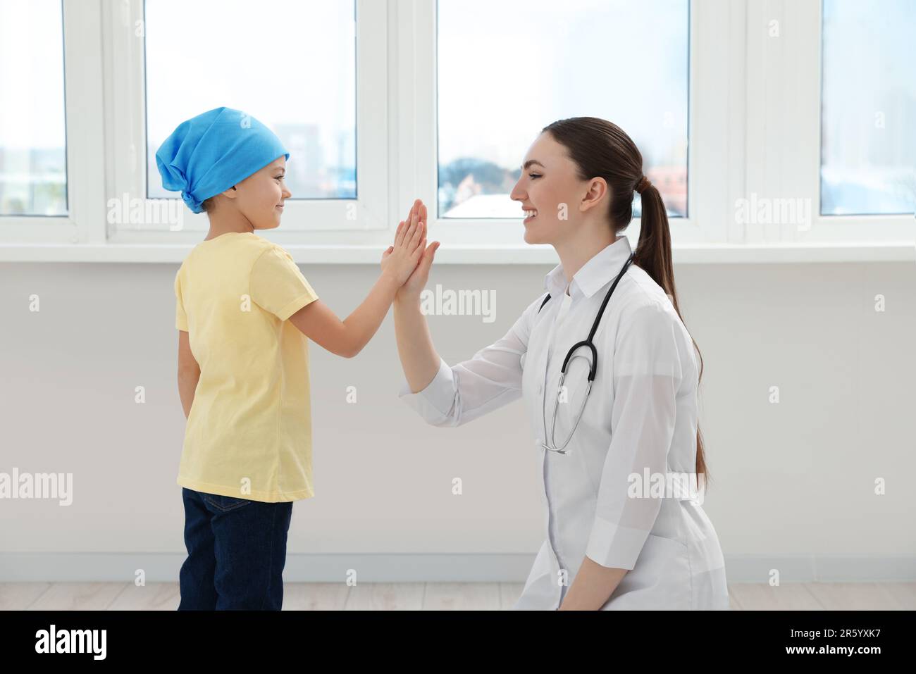 Childhood cancer. Doctor and little patient giving high five in ...