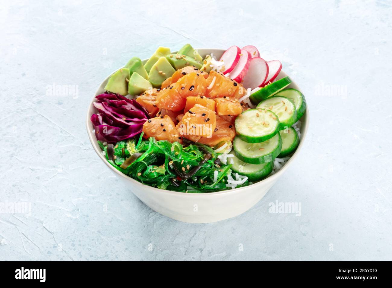 Salmon poke bowl with avocado, cucumbers, wakame, radish, and purple ...