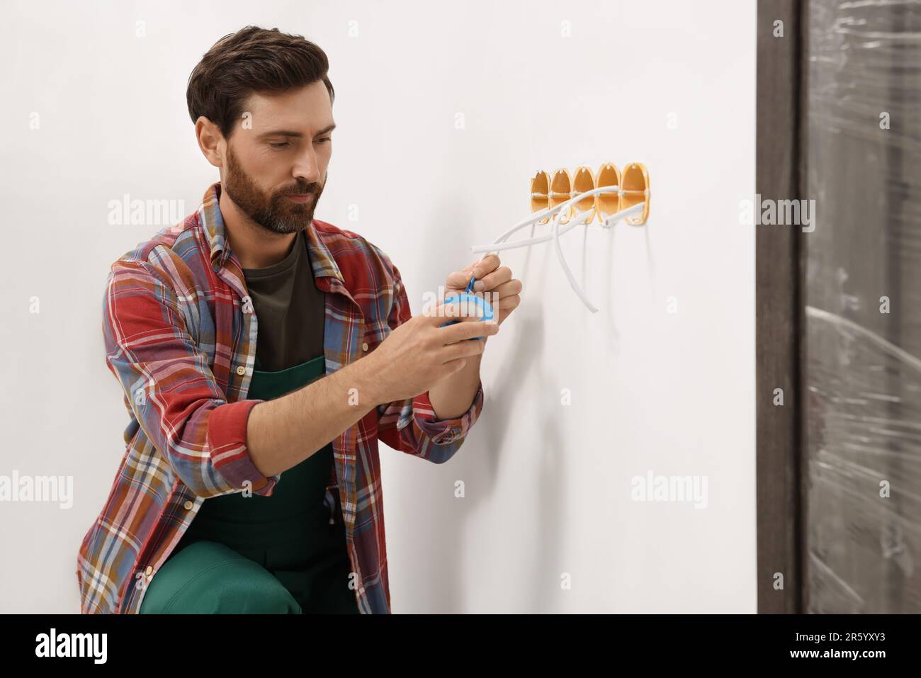 Electrician fixing wires with insulating tape indoors Stock Photo - Alamy