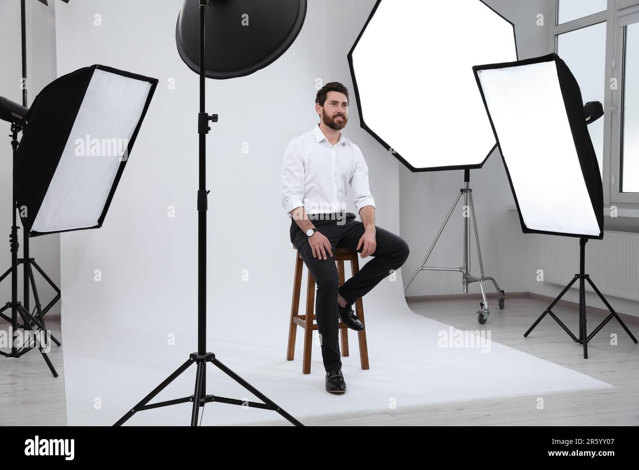 Handsome model posing in modern studio. Professional photo session ...