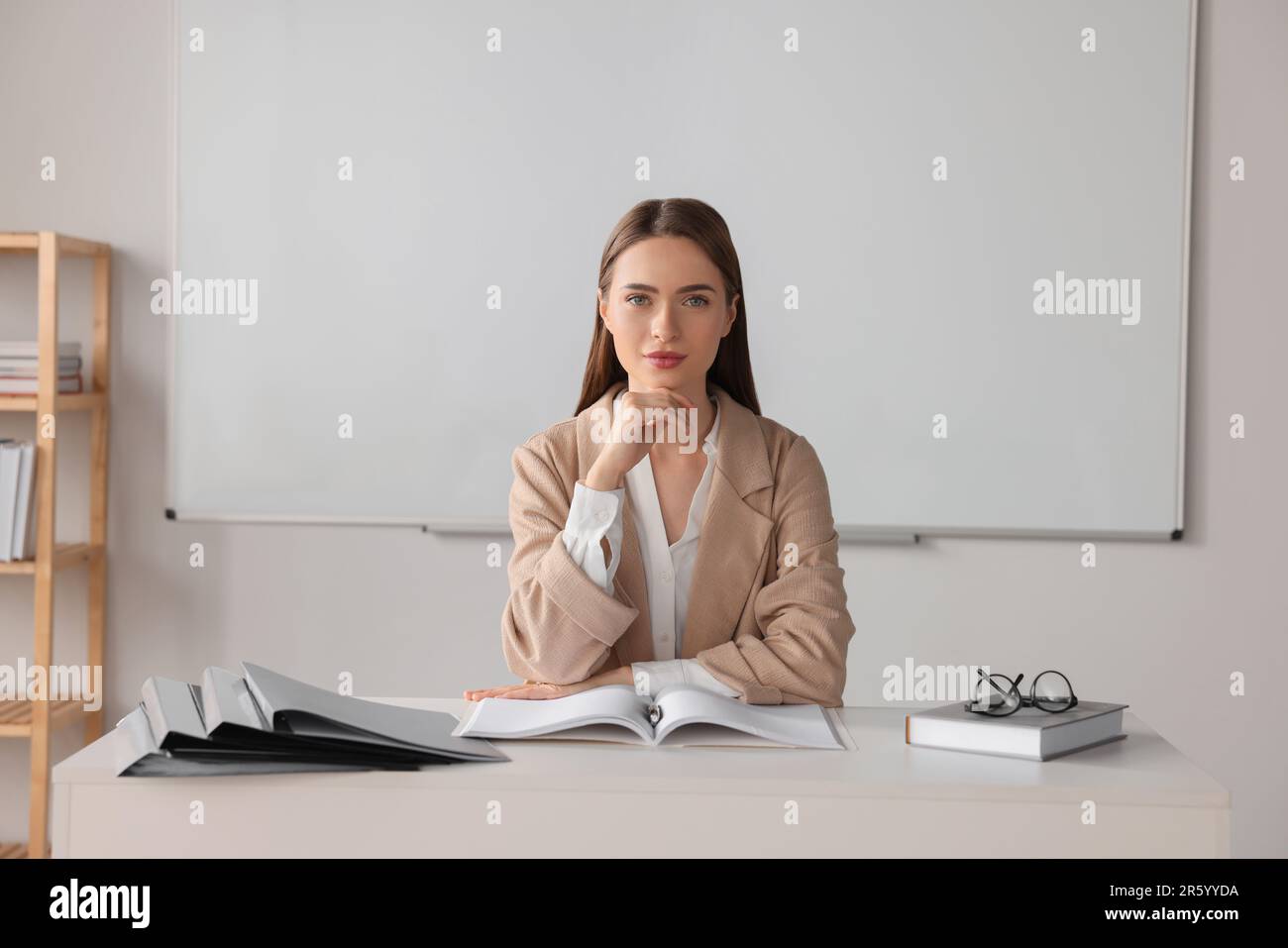 Young teacher sitting table hi-res stock photography and images - Alamy