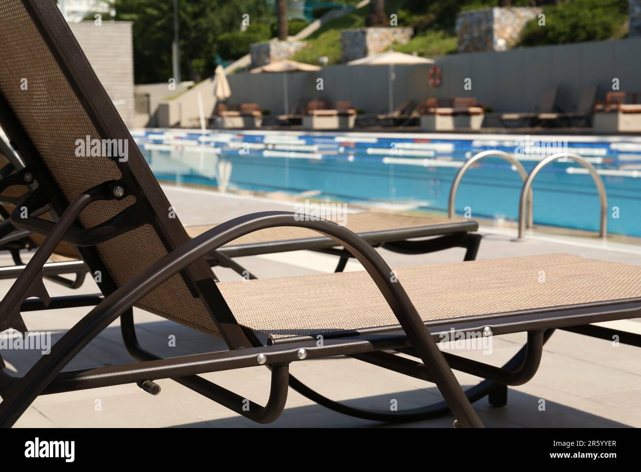 Empty sunbed near outdoor swimming pool at resort Stock Photo - Alamy