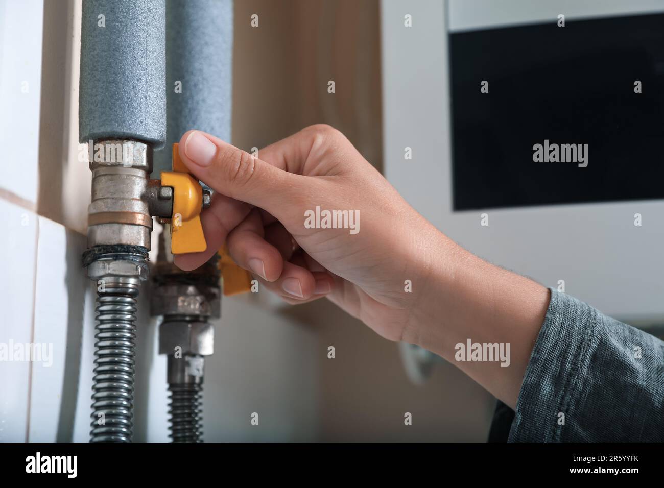 Woman turning on valve hi-res stock photography and images - Alamy