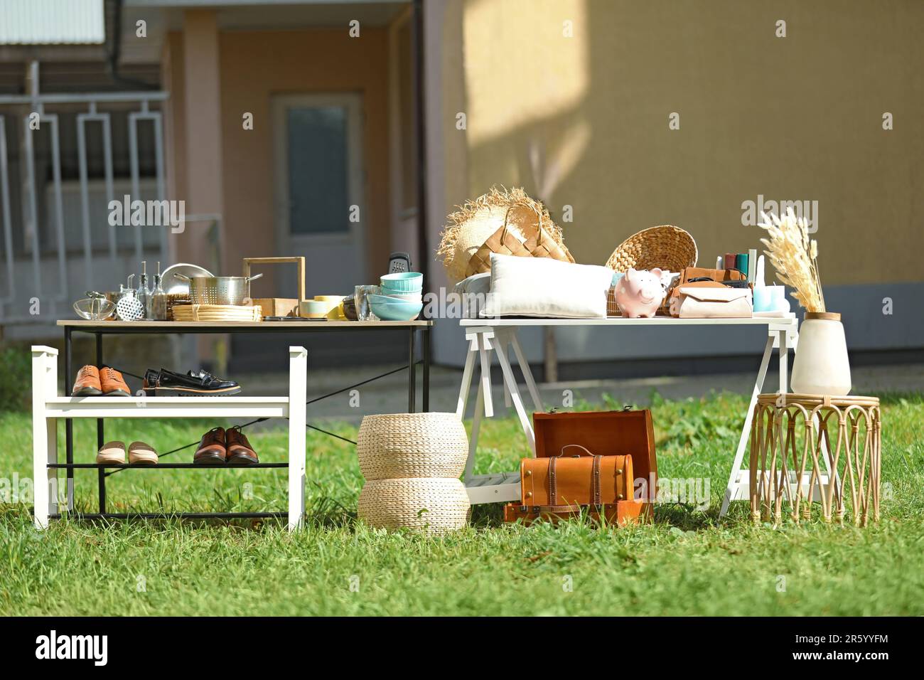 Small tables with many different items on garage sale in yard Stock ...