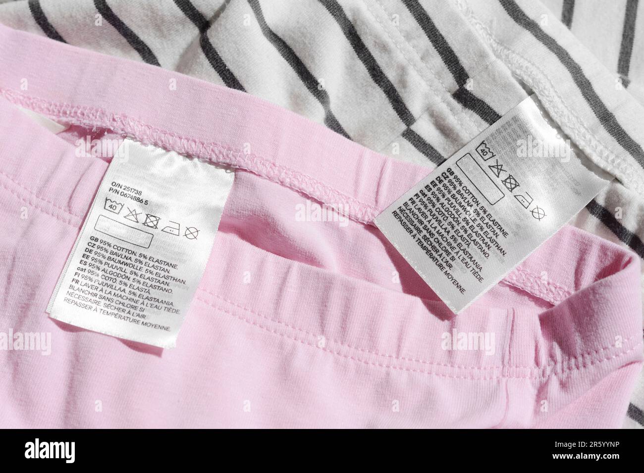 Clothing labels with instructions on garments, top view Stock Photo - Alamy