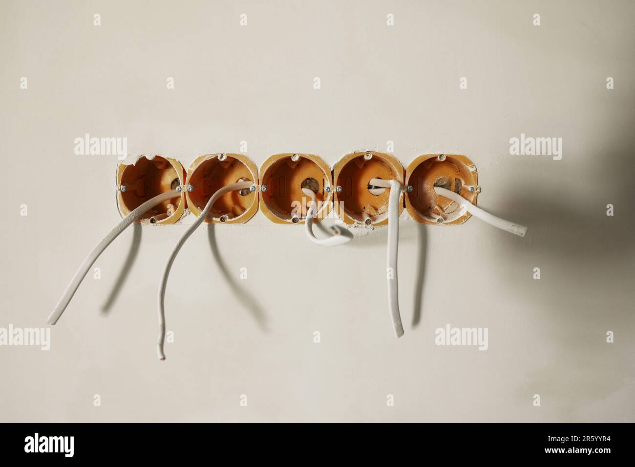 Mounting box with wires on wall, closeup Stock Photo - Alamy