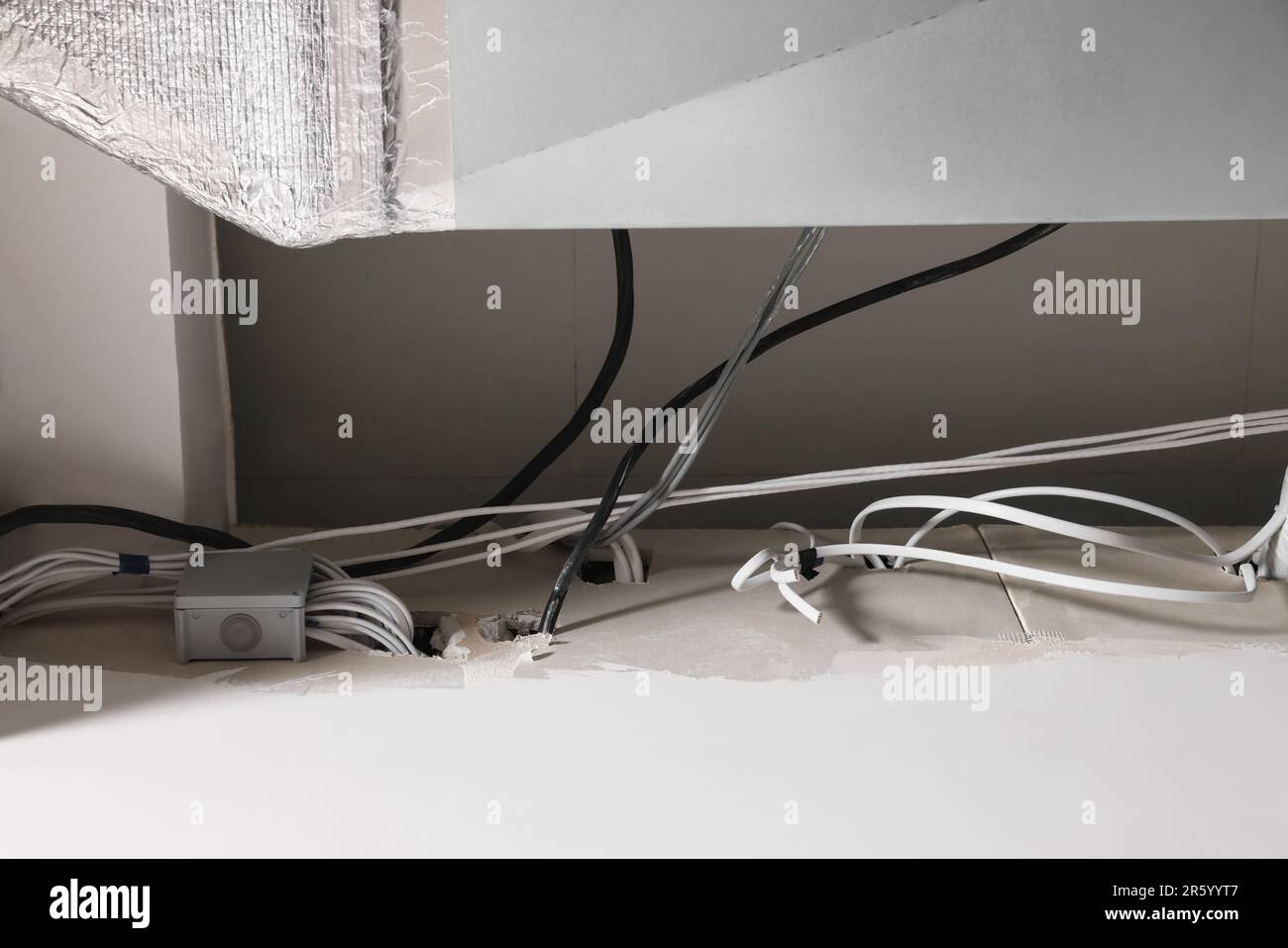 White cables on ceiling, low angle view. Installation of electrical ...