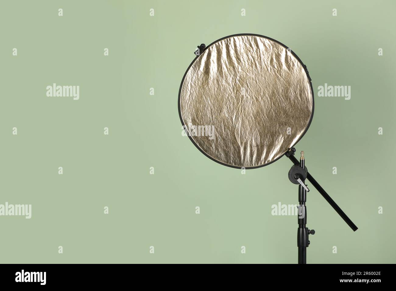 Studio reflector on pale green background, space for text. Professional ...