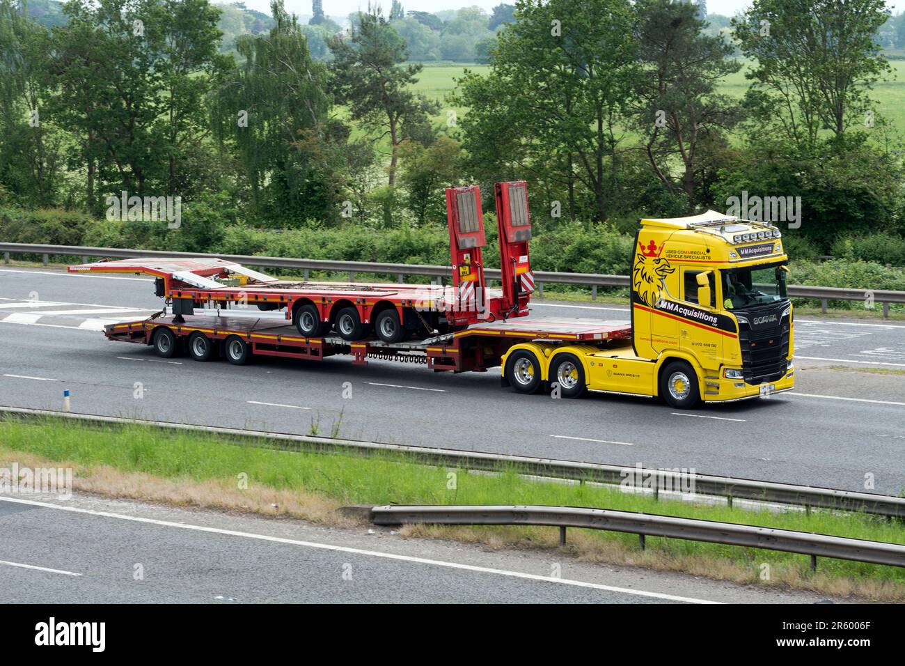 MM Acquisitions lorry carrying a low-loader trailer, M40 motorway ...