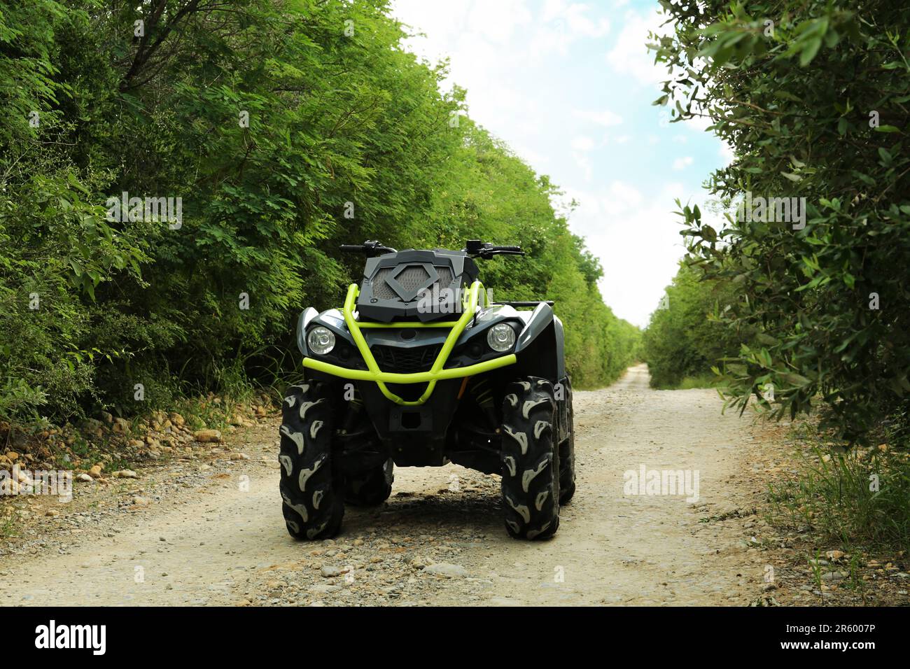 Modern quad bike on pathway near trees outdoors Stock Photo - Alamy