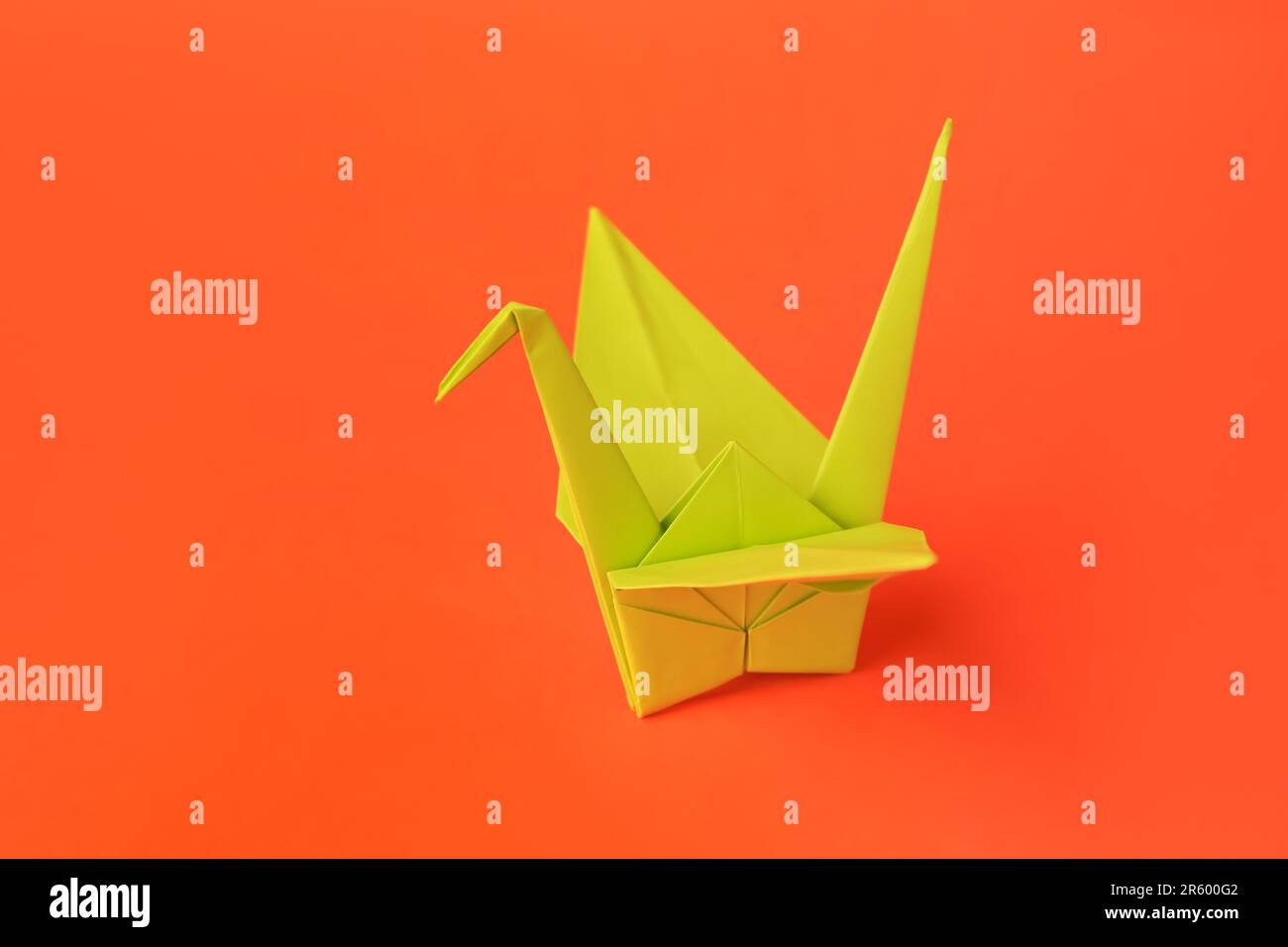Origami art. Handmade paper crane on orange background Stock Photo - Alamy