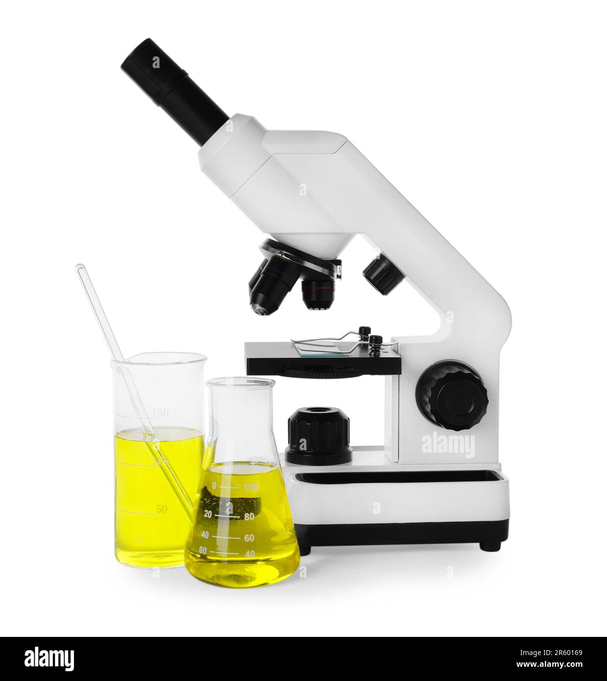 Laboratory glassware with yellow liquid and microscope isolated on ...