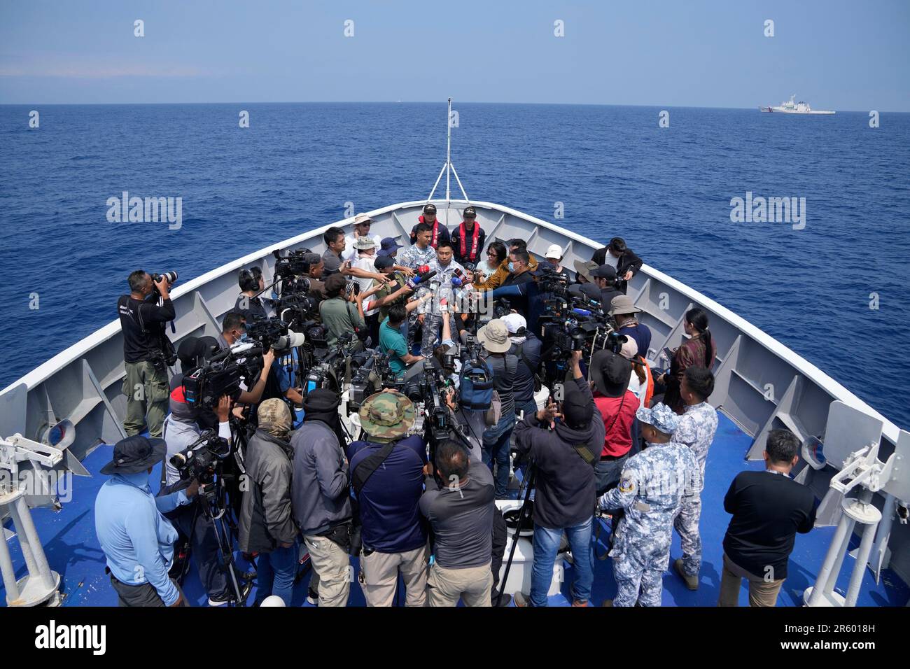A Philippine Coast Guard personnel is interviewed by reporters on board ...