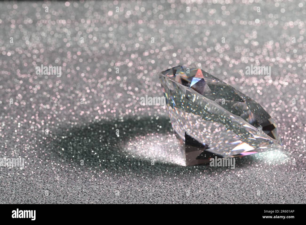 Beautiful dazzling diamond on silver glitter background, closeup. Space ...