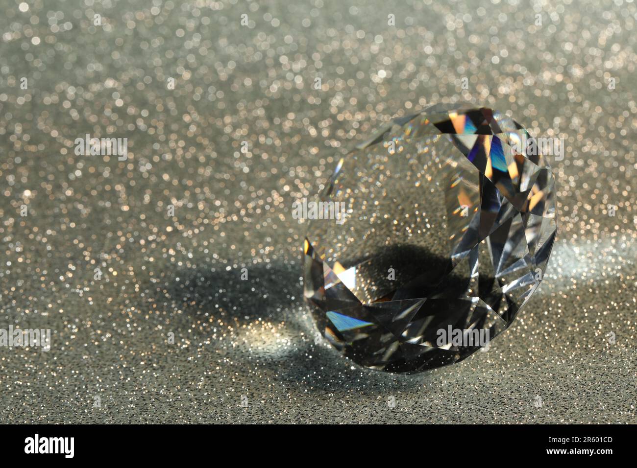 Beautiful dazzling diamond on glitter background, closeup. Space for ...