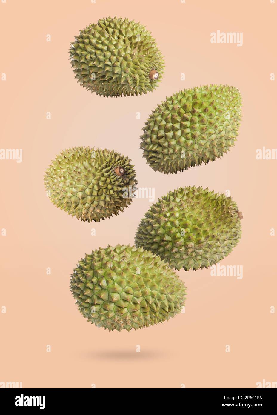 Whole ripe durians falling on beige background Stock Photo - Alamy