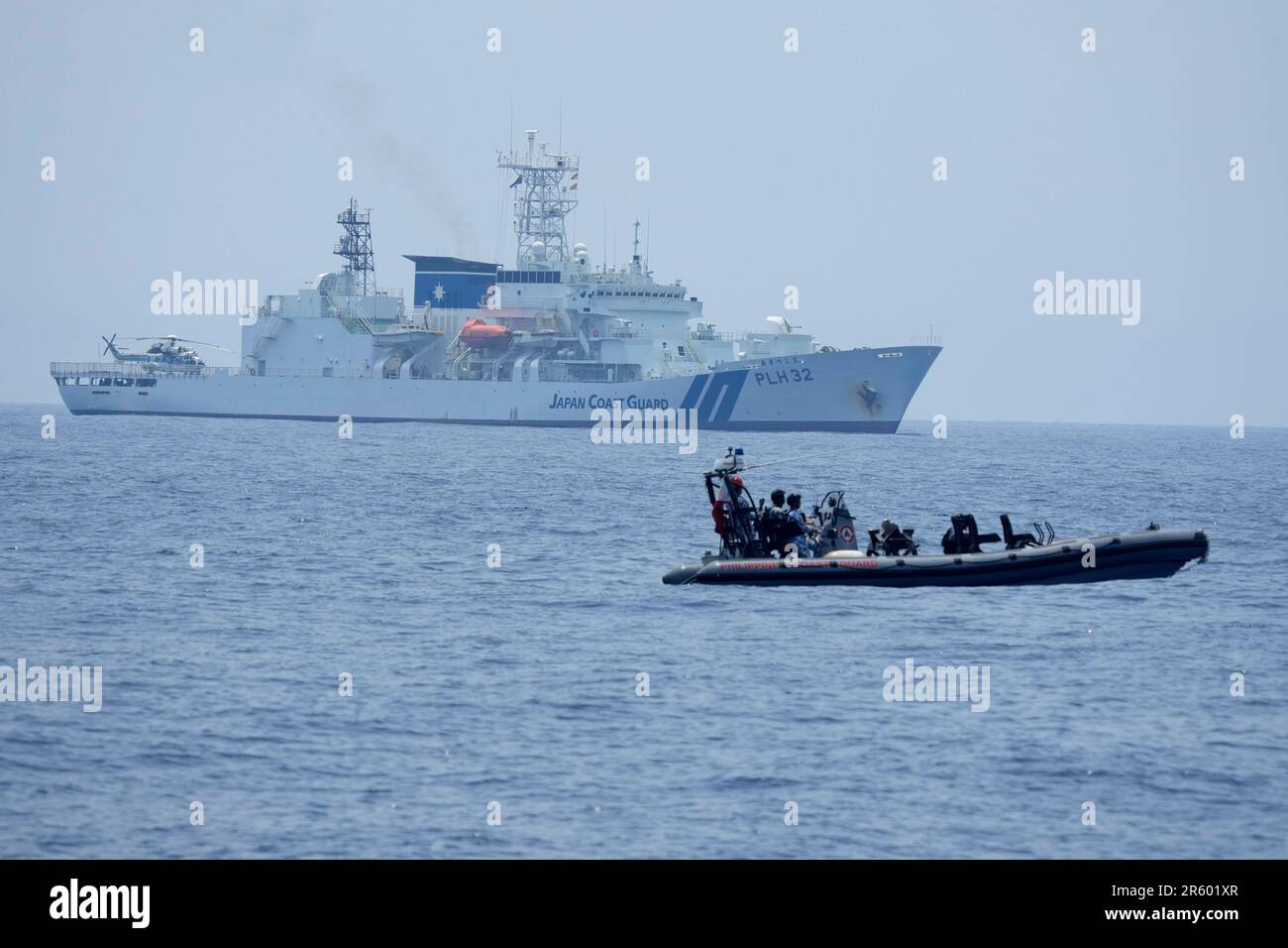 A Philippine Coast Guard rigid hull inflatable boat passes by the Japanese Coast Guard ...