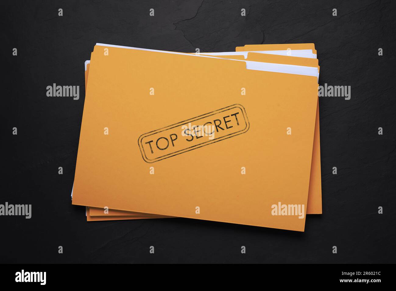 Yellow file with documents and Top Secret stamp on black table, top ...