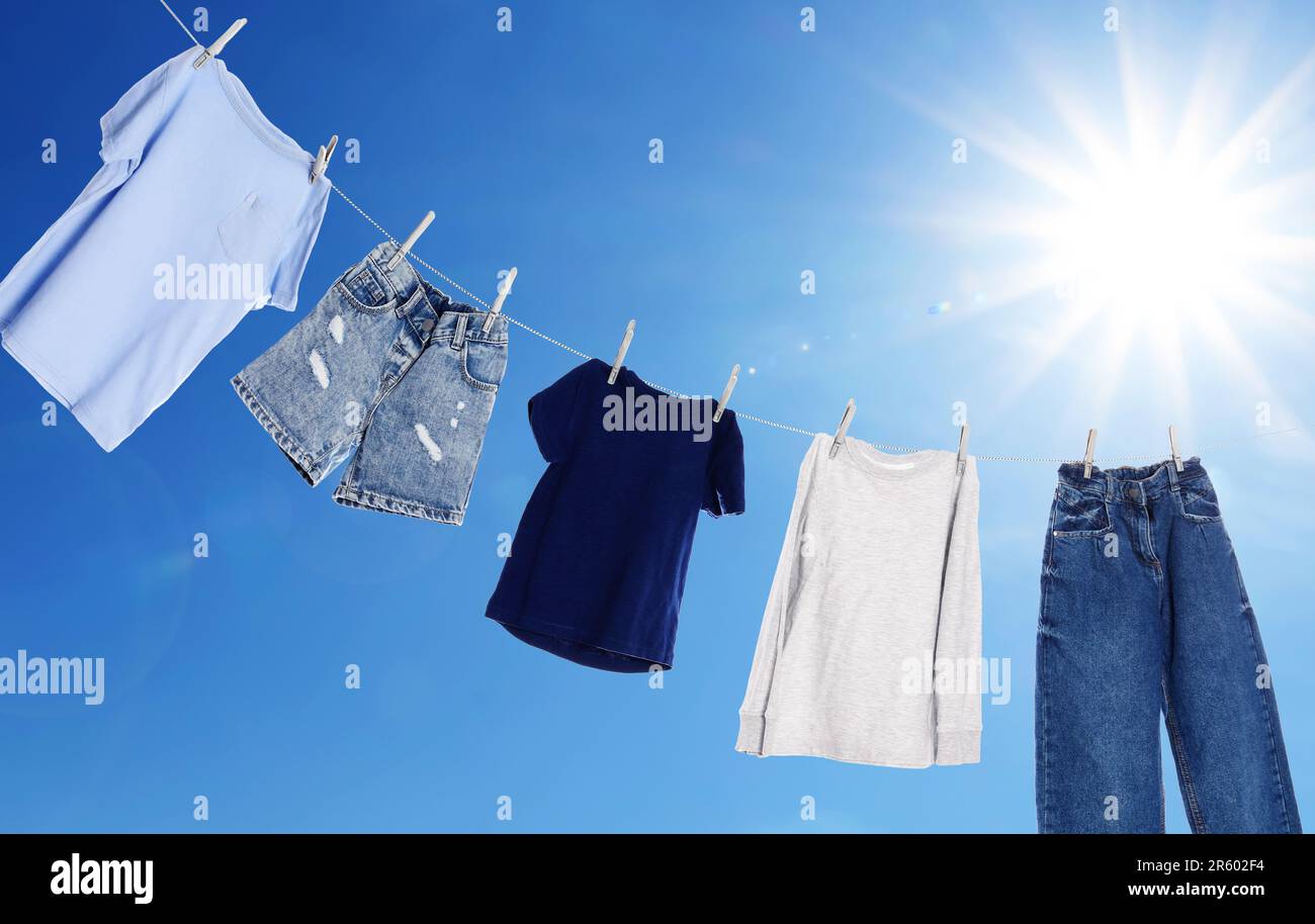 Different clothes drying on washing line against blue sky Stock Photo ...