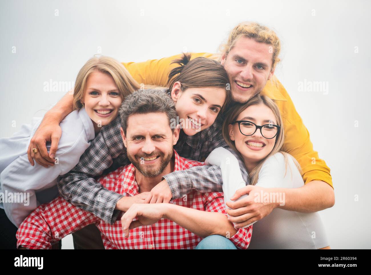 Smiling group of friends laughing. Group of friends embrace together ...