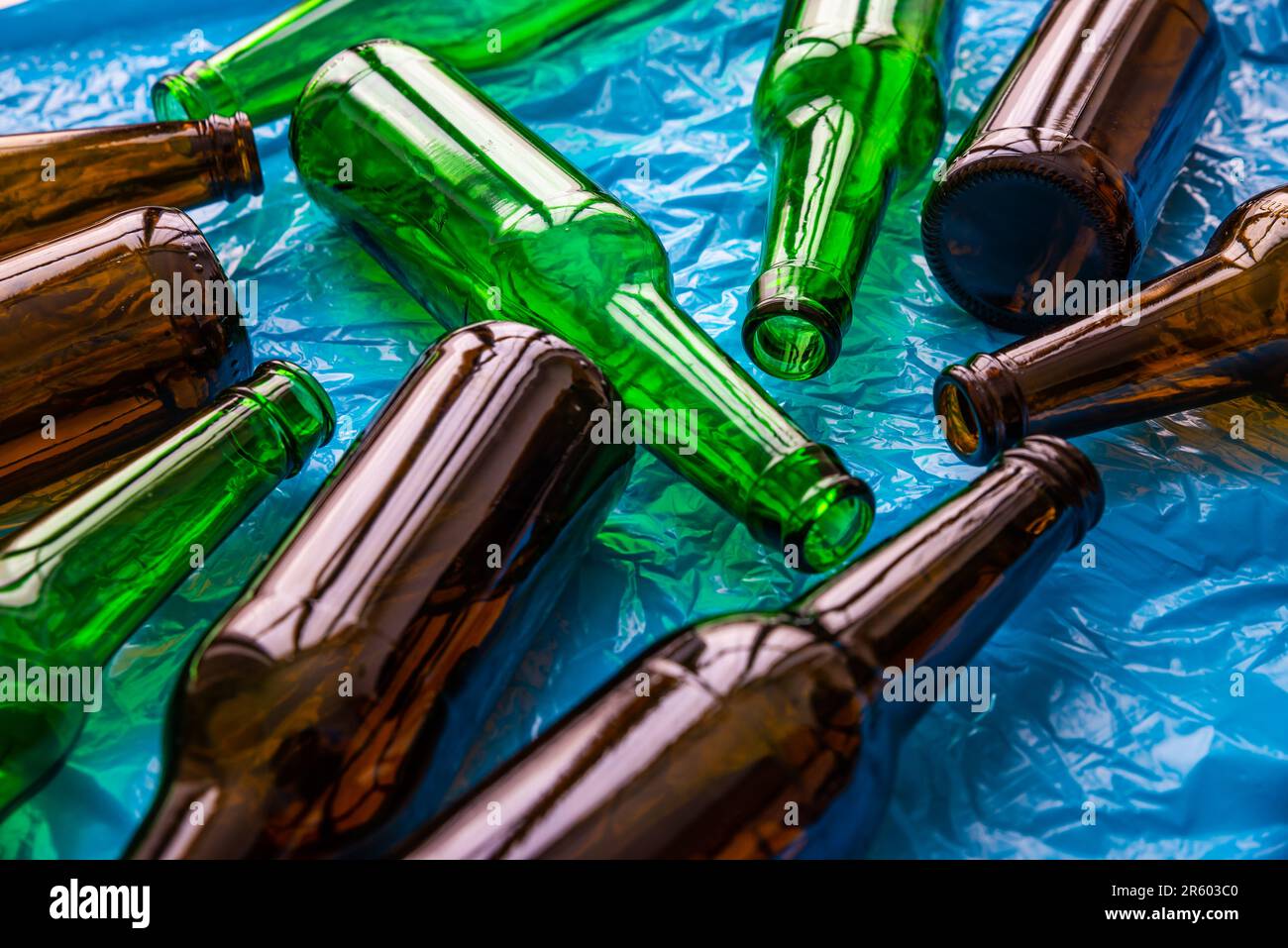 Empty beer or beverage bottles on blue surface. Reuse and recycling of ...