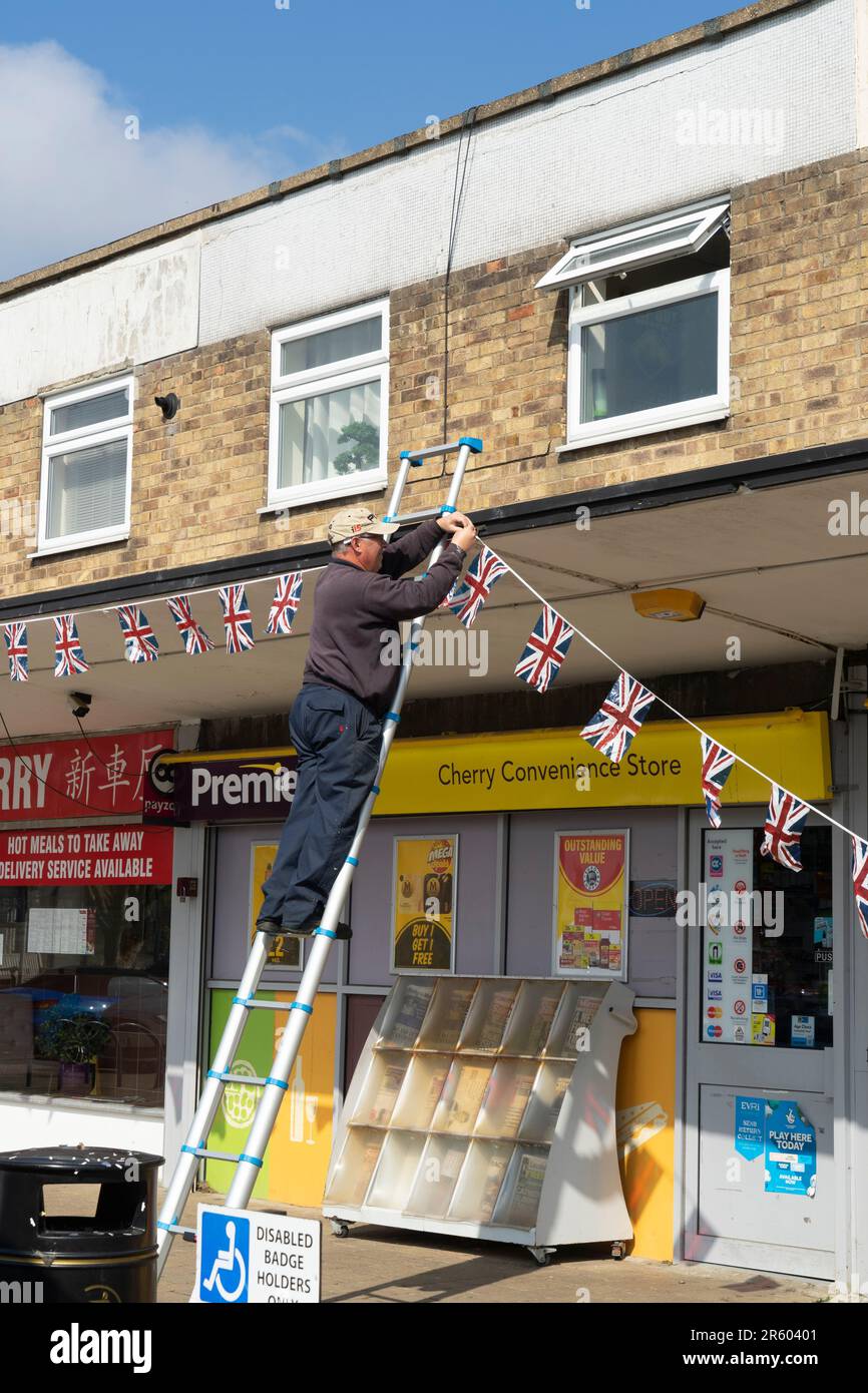 Man hanging union flag bunting at shopping centre celebrating Charles ...