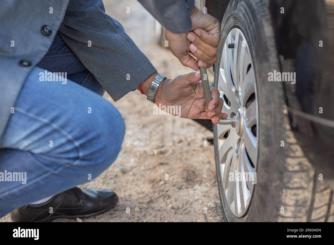 Detail of a Latino man loosening a nut to change a flat tire Stock ...