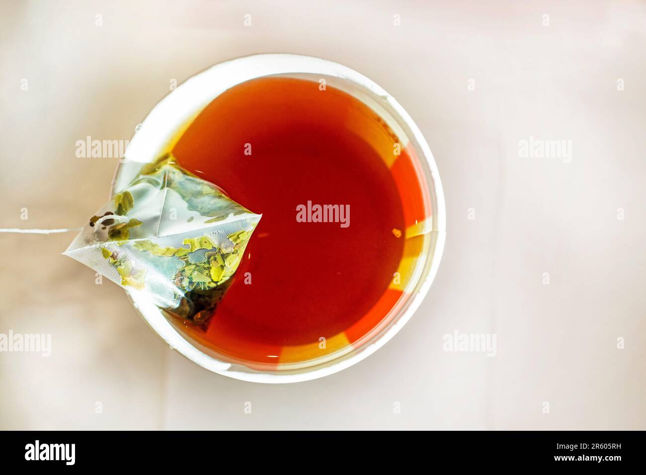 brew a bag of green tea in a bag in a disposable glass of hot water, a ...