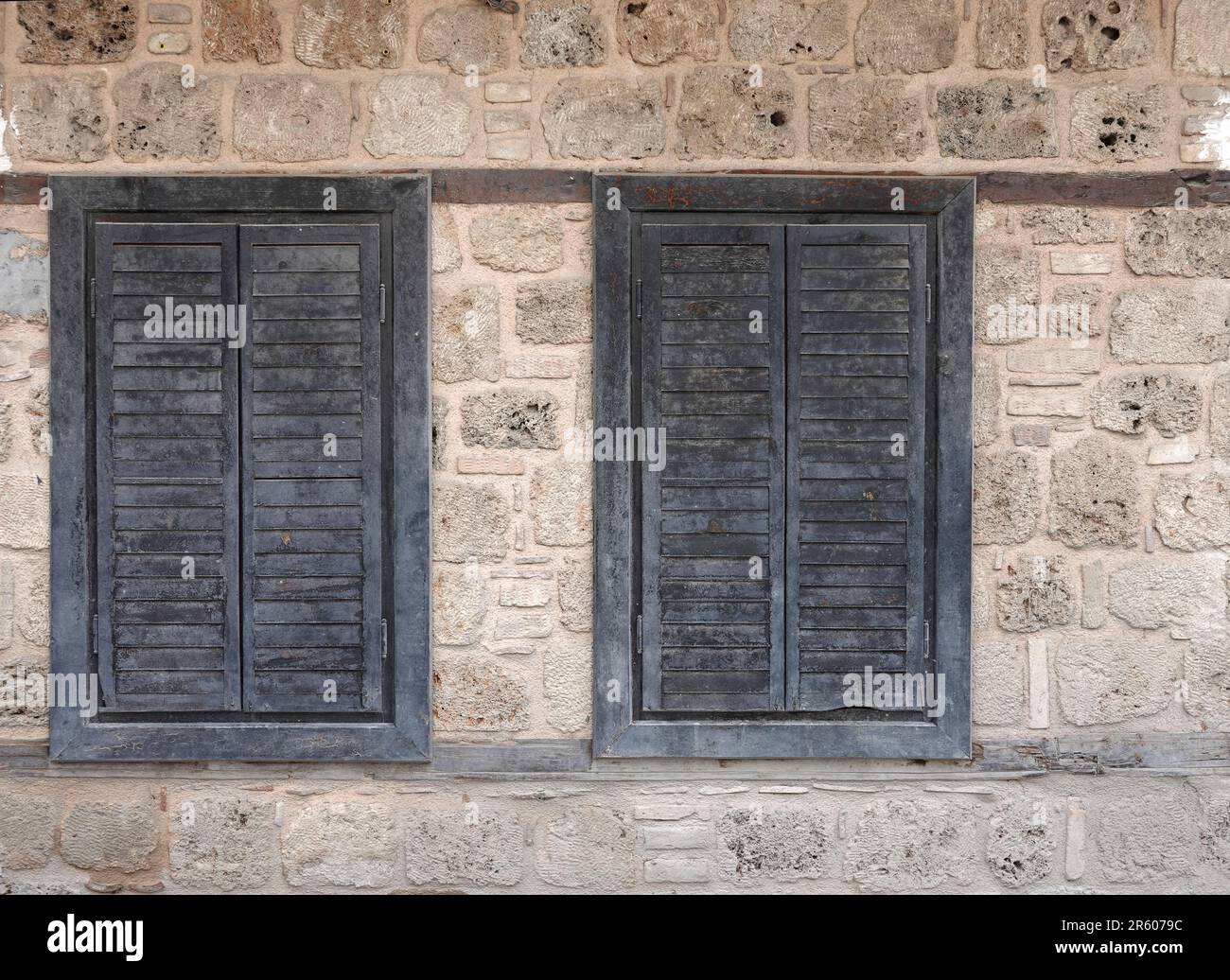 Vintage ancient wall from old sandy limestone and two closed windows ...