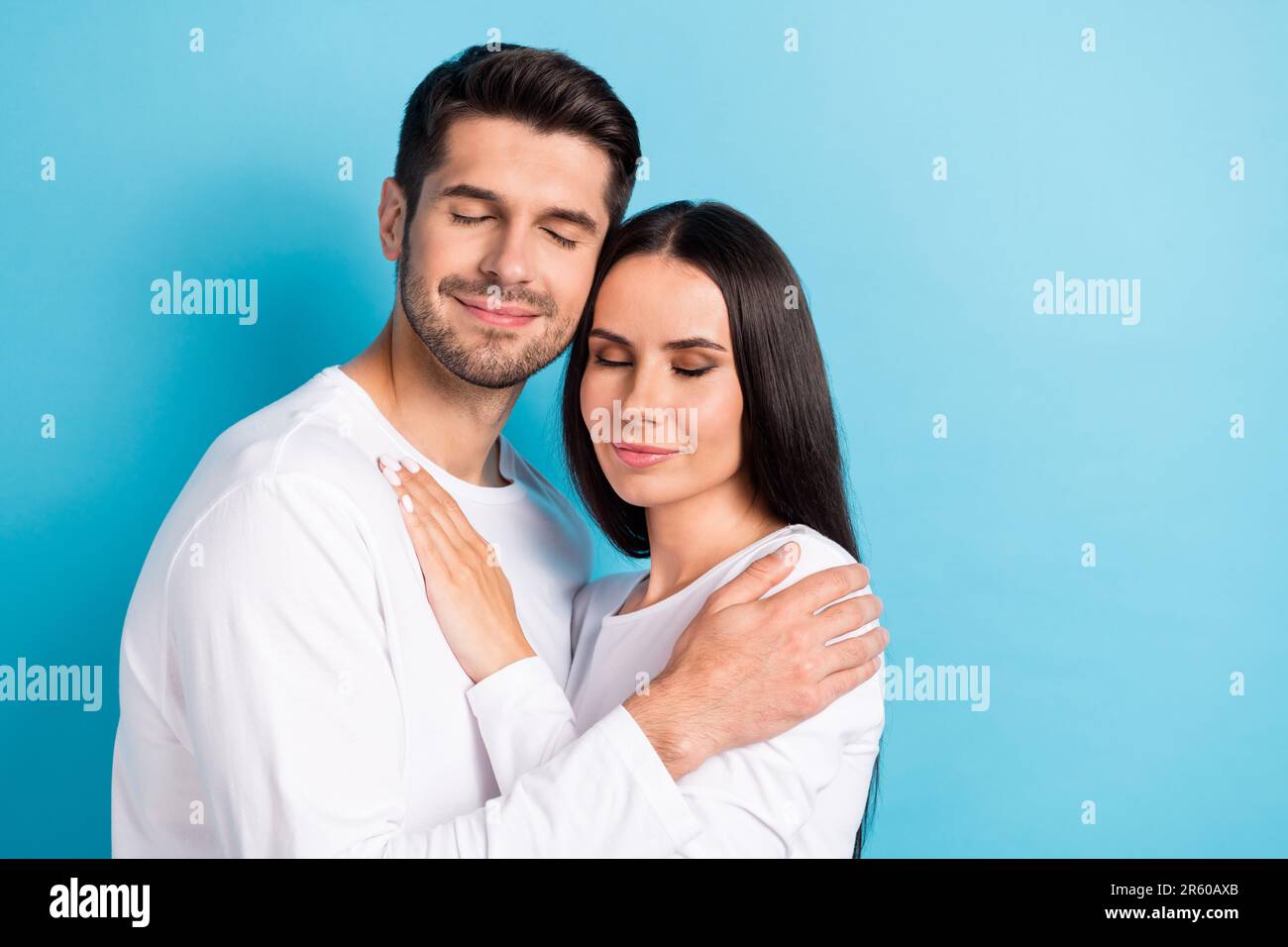 Photo of two positive idyllic people cuddle closed eyes empty space ad ...