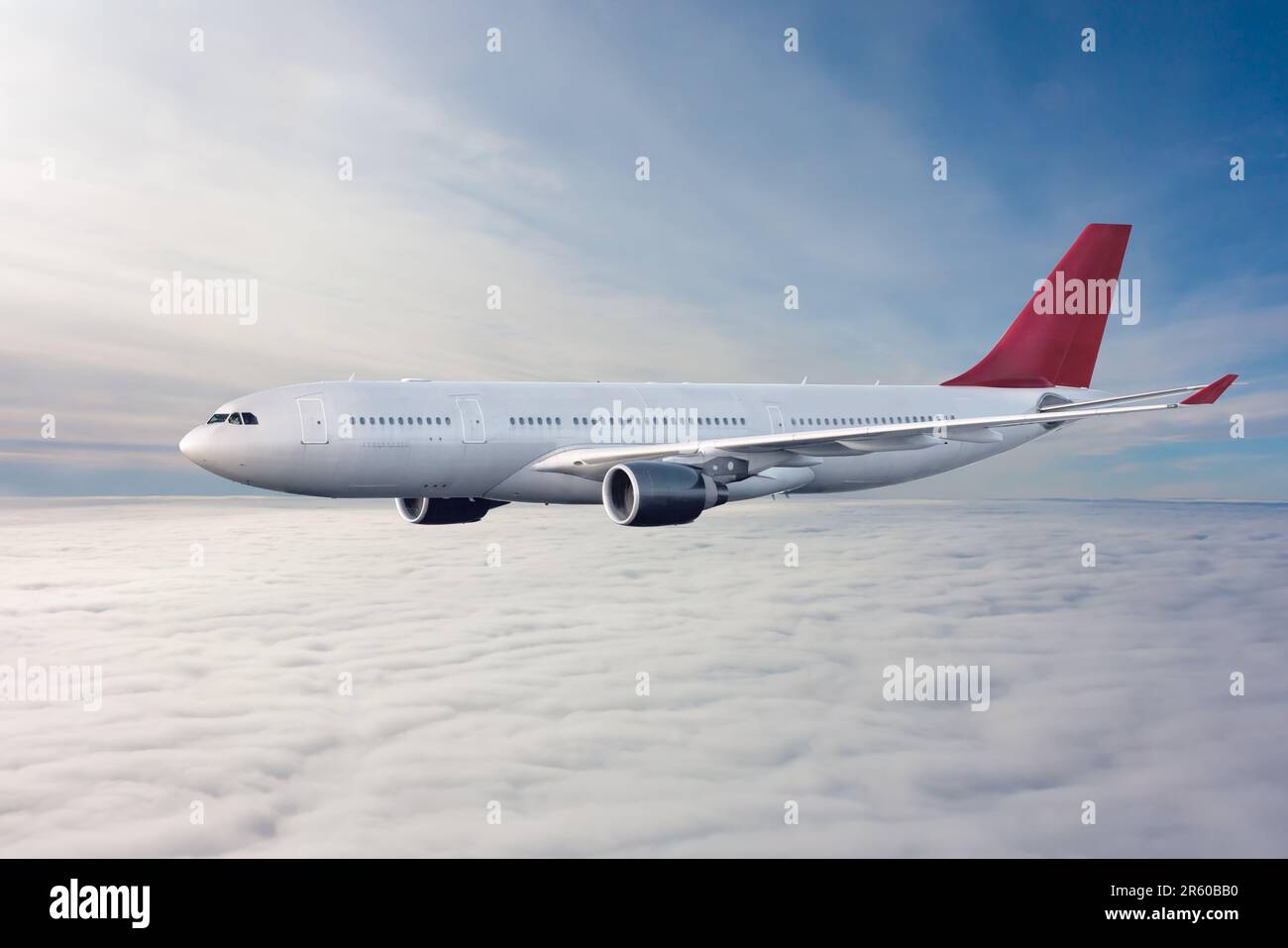 Wide body passenger airplane flying in the air above the clouds Stock ...