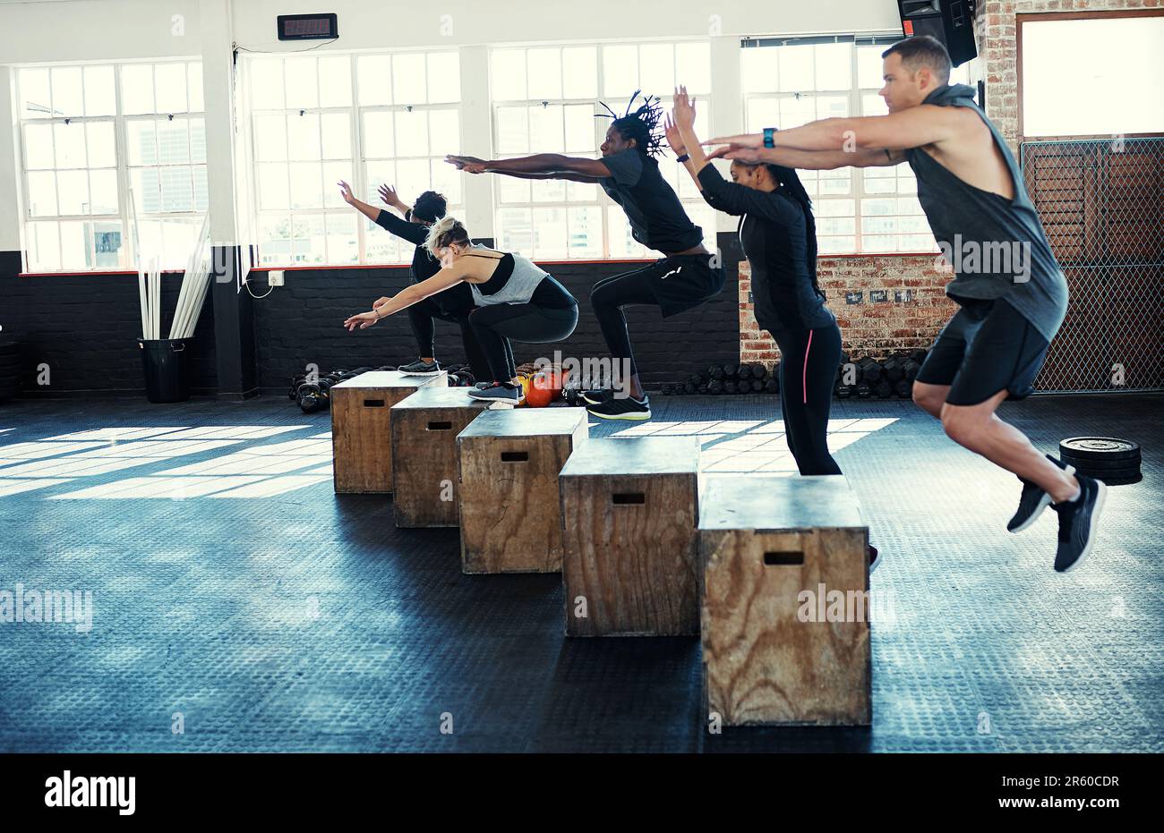 And jump. a focused group of young people jumping onto crates as ...
