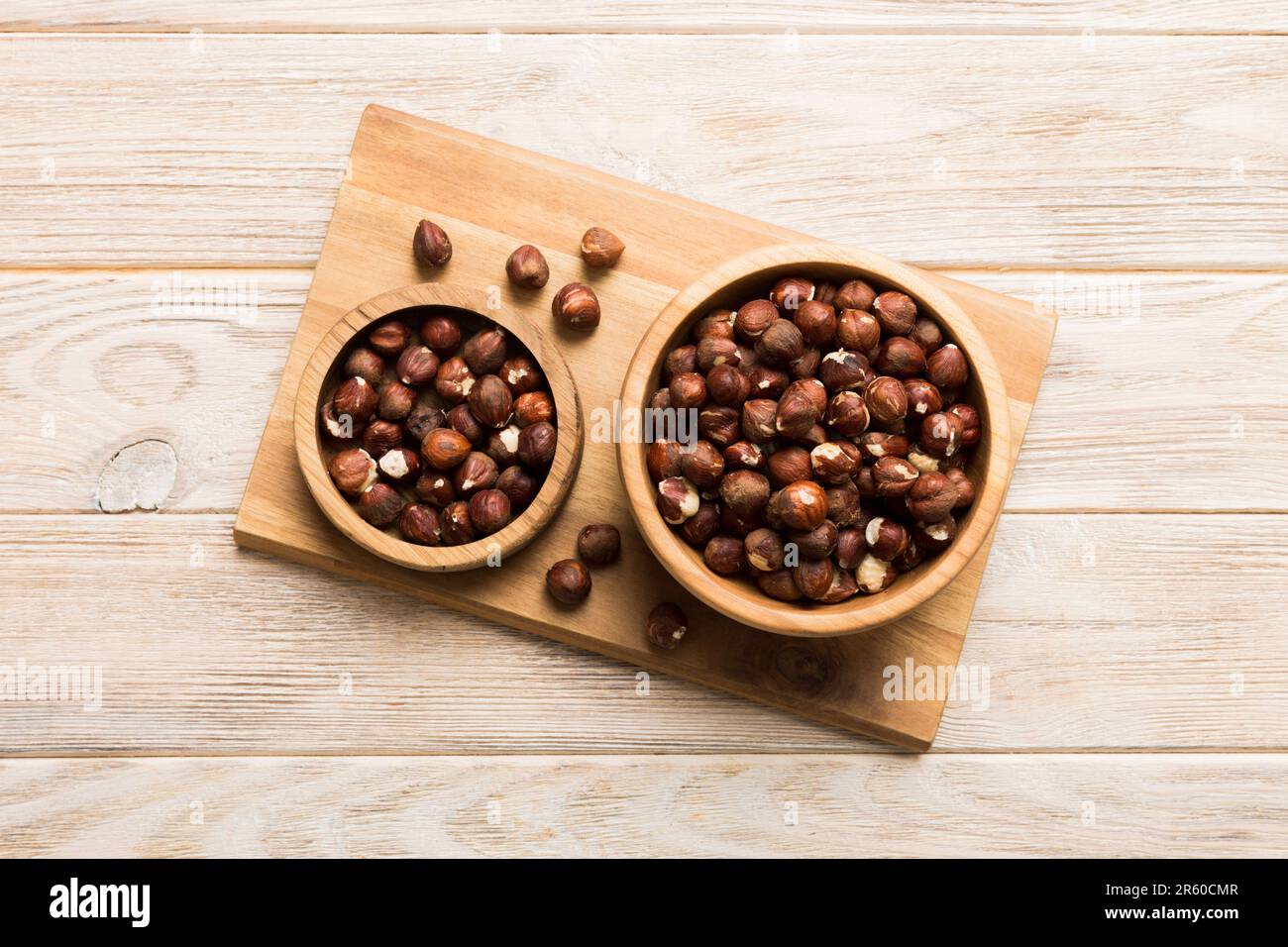 Wooden bowl full of hazelnuts on table background. Healthy eating ...