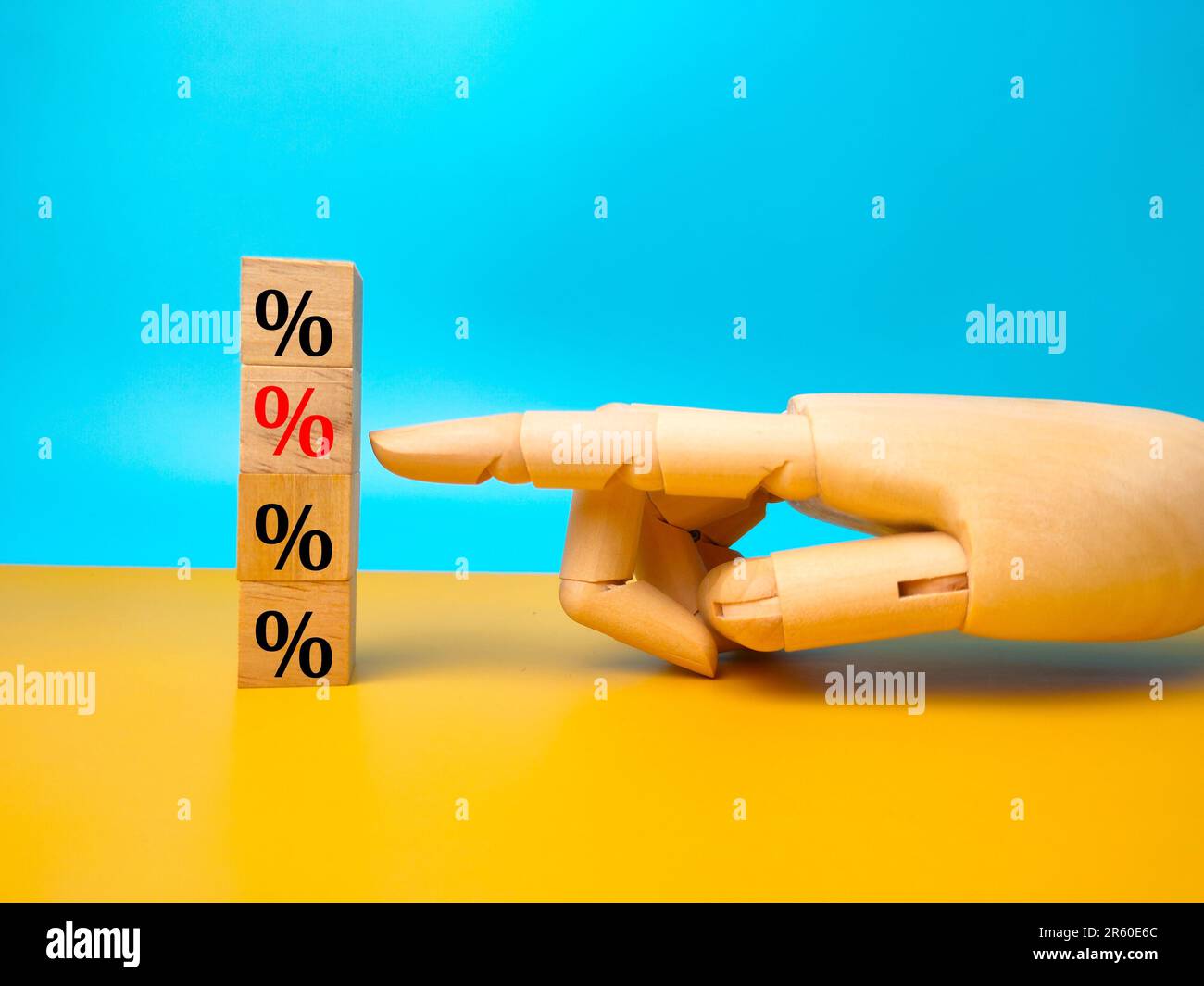 A close-up of a finger pointing to a percent sign that is carved into a ...