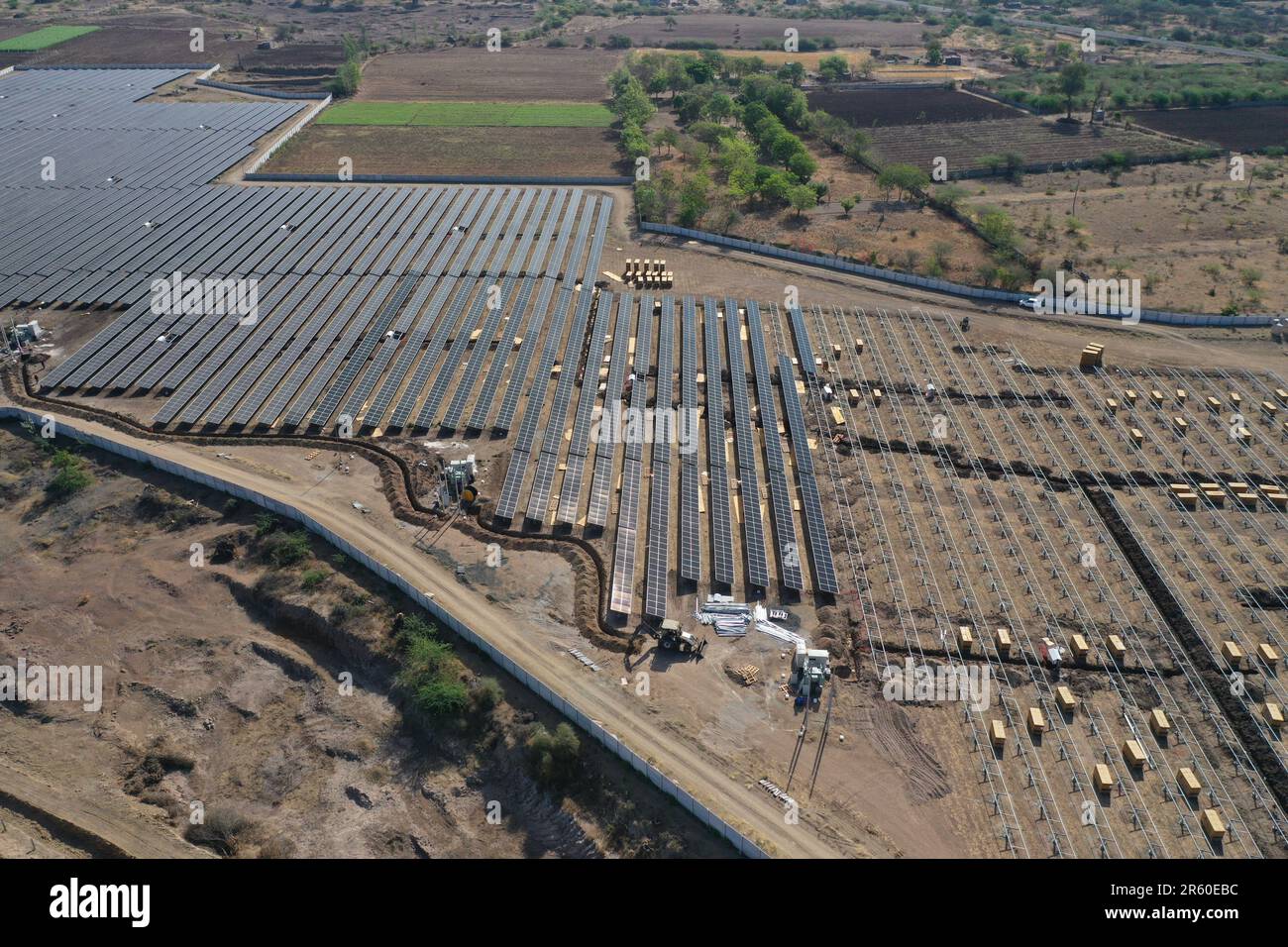 An array of solar panels installed in a rural field, with electrical ...