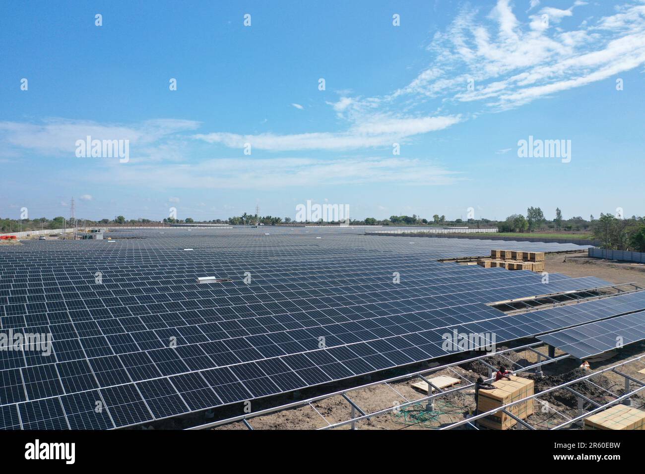 An aerial view of a large-scale solar farm with an array of black solar ...