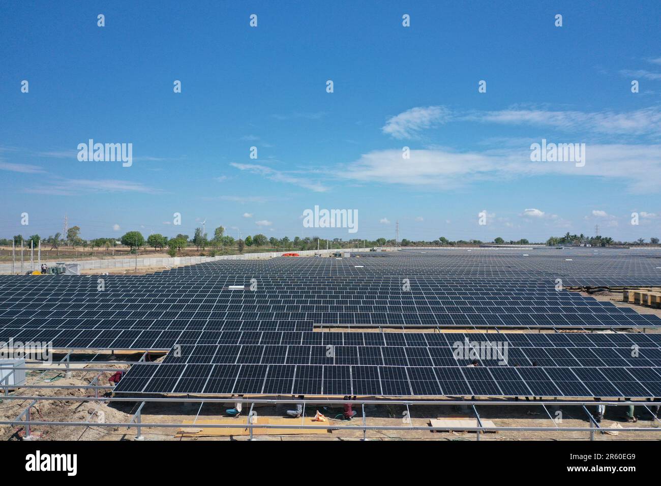 An aerial view of a large-scale solar farm with an array of black solar ...