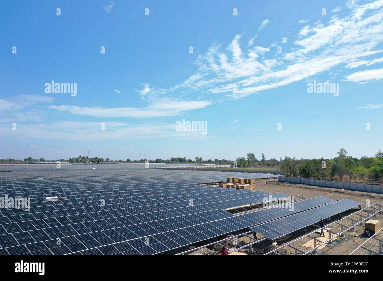 An aerial view of a large-scale solar farm with an array of black solar ...