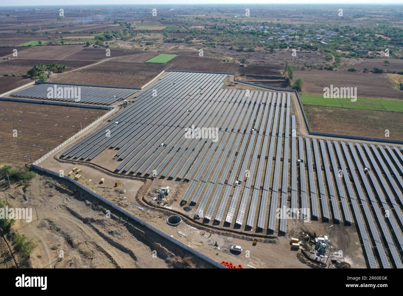 An aerial view of a large-scale solar farm with an array of black solar ...