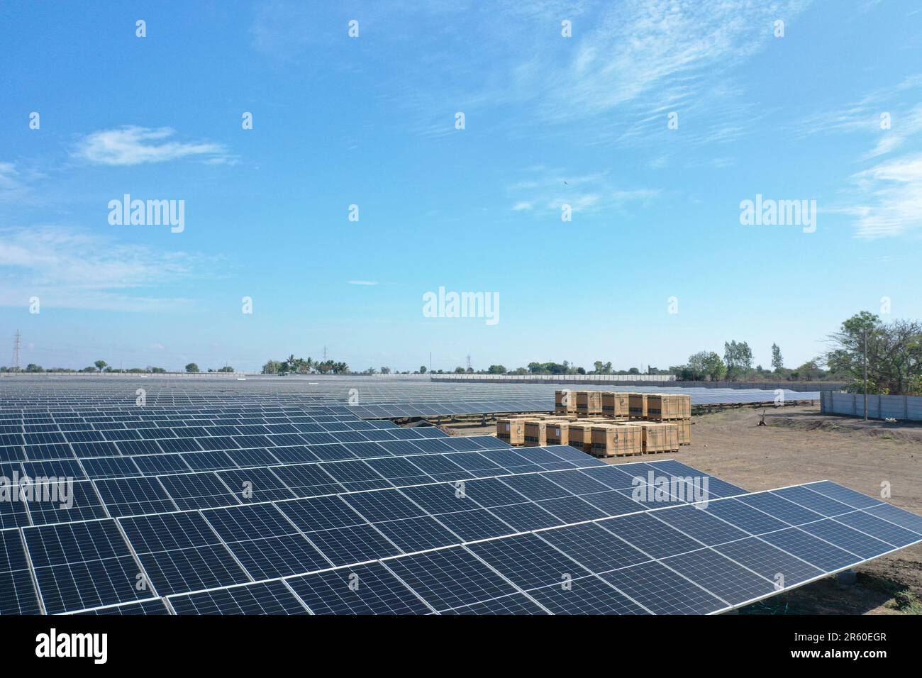 An aerial view of a large-scale solar farm with an array of black solar ...