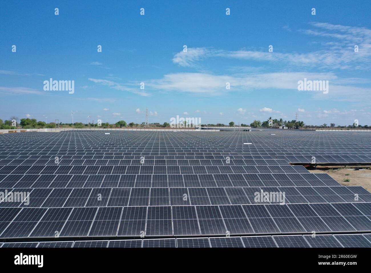 An aerial view of a large-scale solar farm with an array of black solar ...