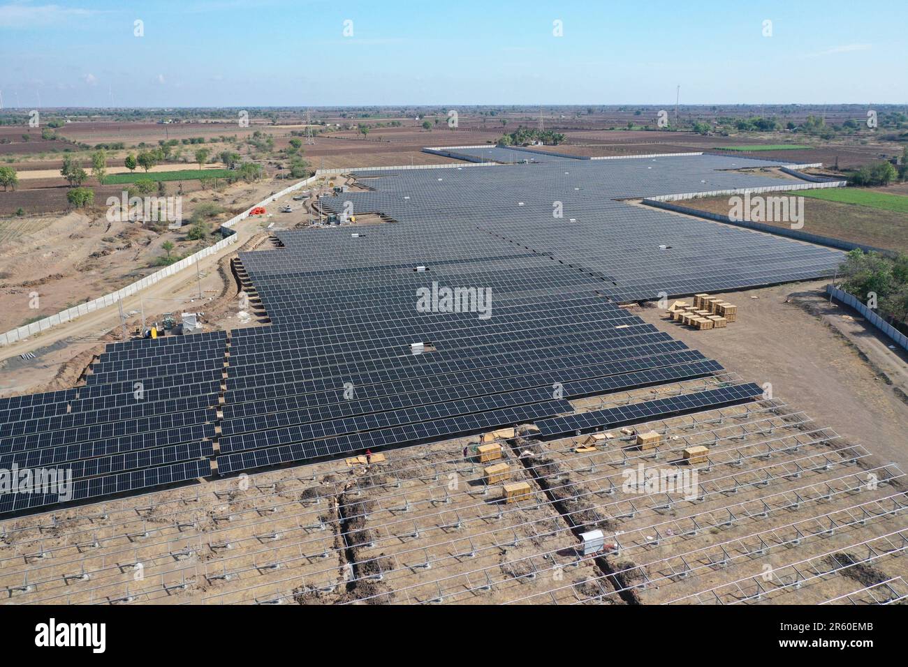 An aerial view of a large-scale solar farm with an array of black solar ...